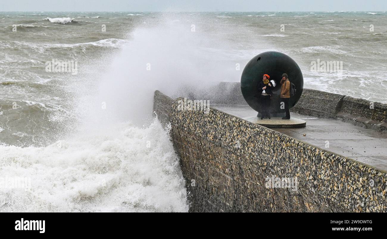 Brighton UK 27th December 2023 - Visitors get wet as waves crash onto ...