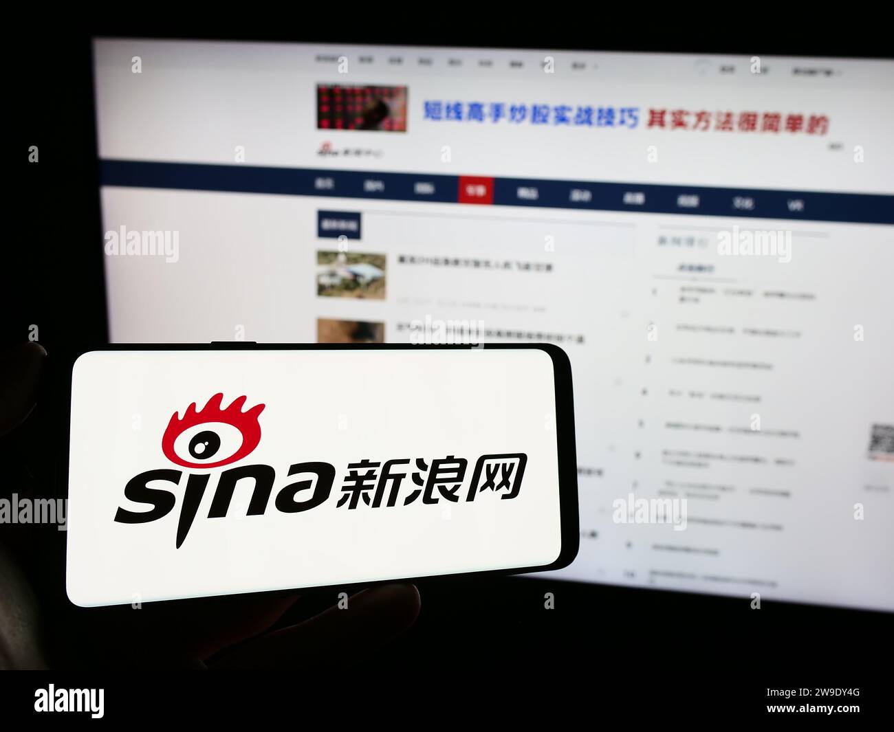 Person holding mobile phone with logo of Chinese technology company ...