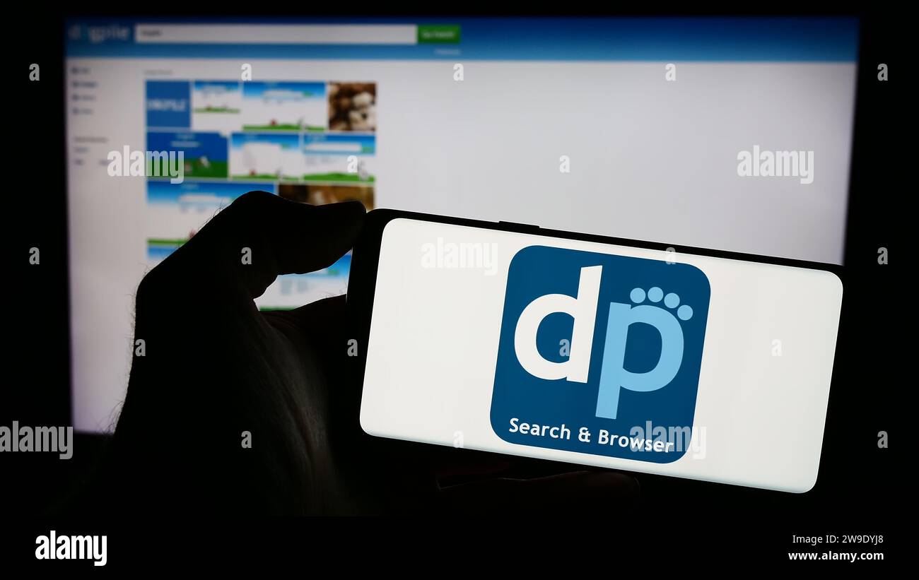 Person holding mobile phone with logo of metasearch engine Dogpile in ...