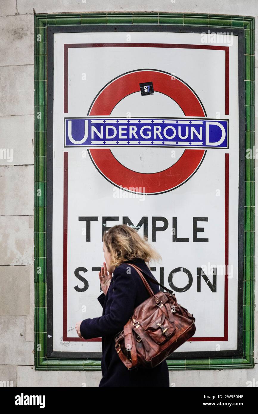 Woman walking past Temple Station Underground sign, London Underground ...
