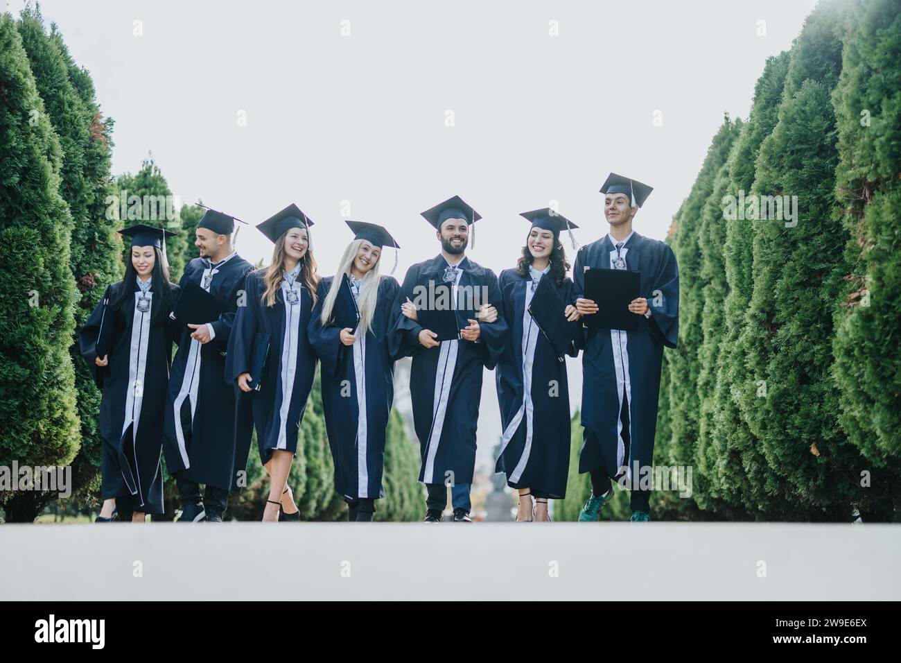 Recent college graduates in graduation caps and gowns, celebrating ...