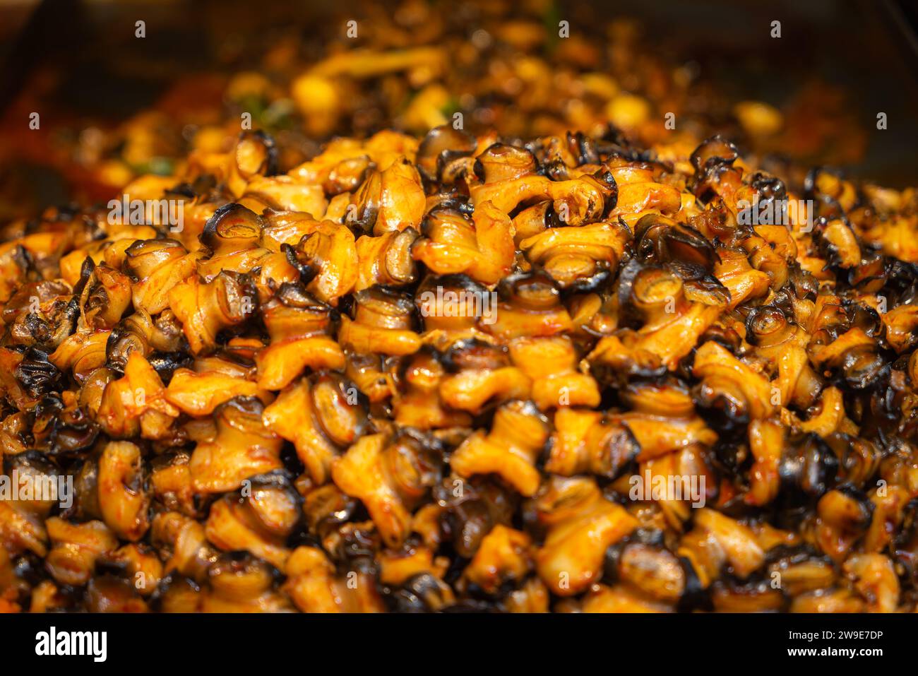 Close-up of golden brown fried snails, a popular street food in Wuchang ...