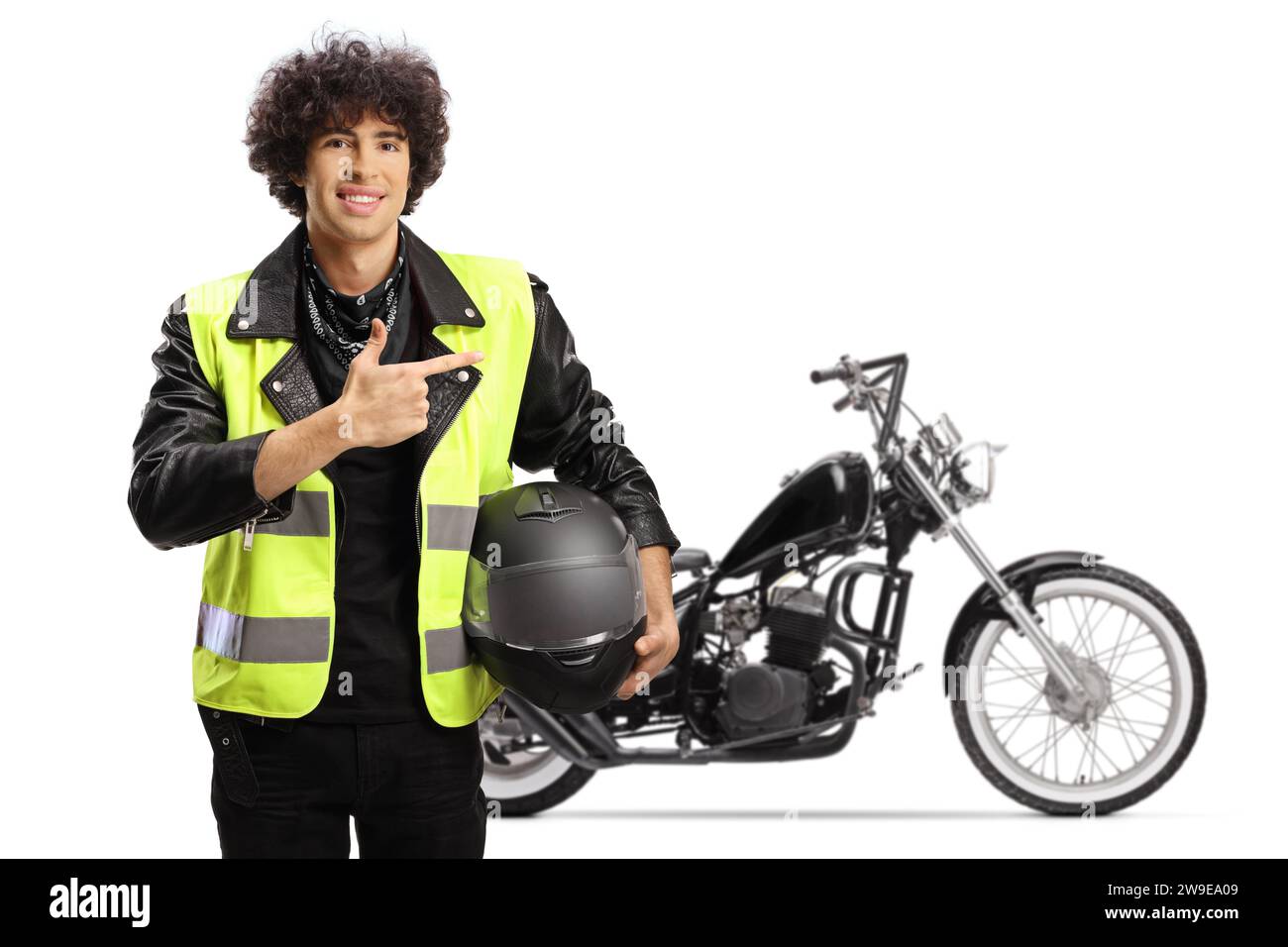 Young man holding a helmet, wearing a traffic safety vest and pointing ...