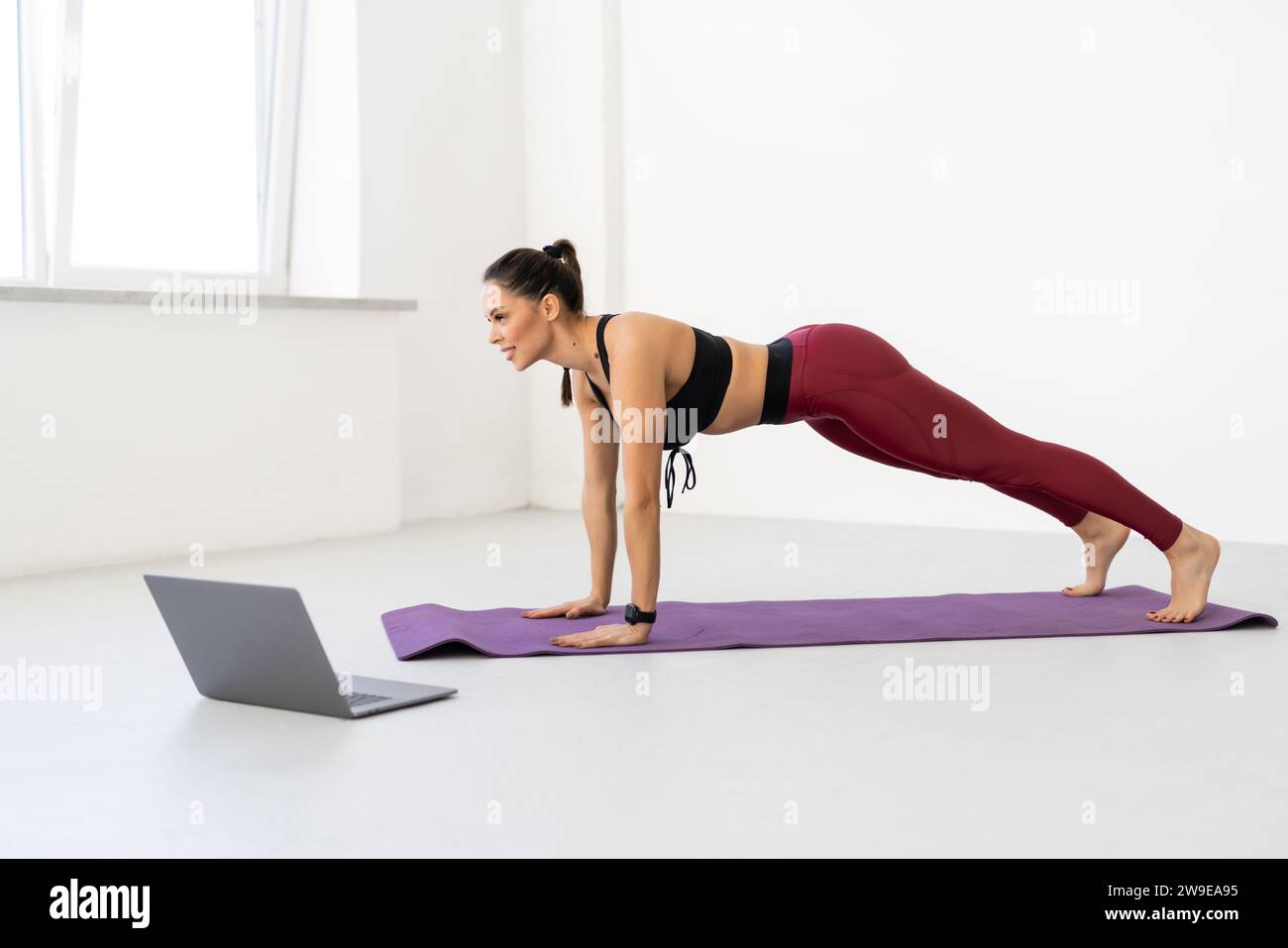 Online workout programs. Pretty brunette long-haired young sporty lady ...