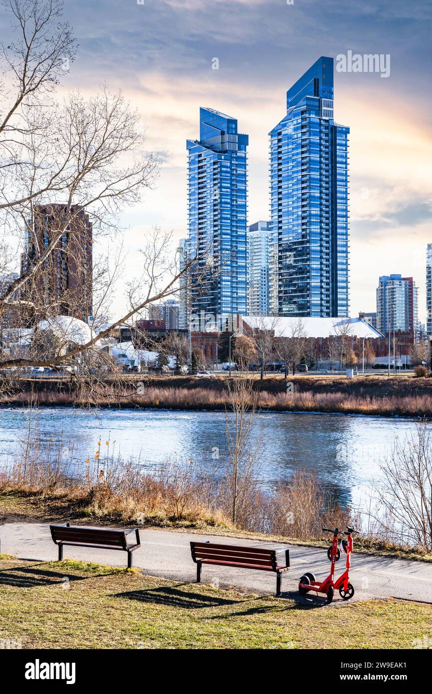 Park benches and E-scooter overlook the Bow River with new apartment ...