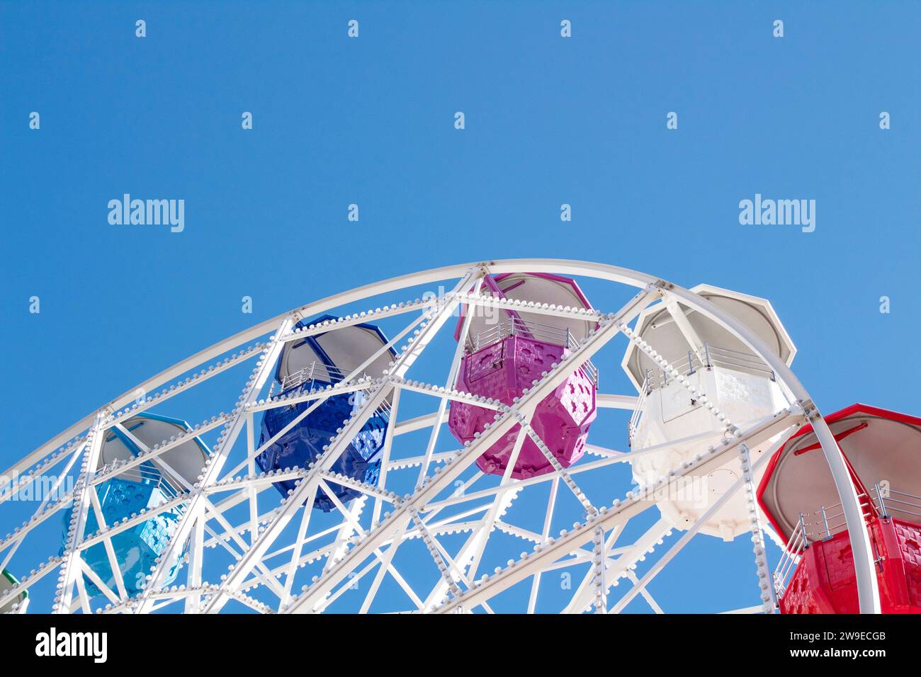Ferris wheel with multi-colored cabs on a background of blue sky Stock ...