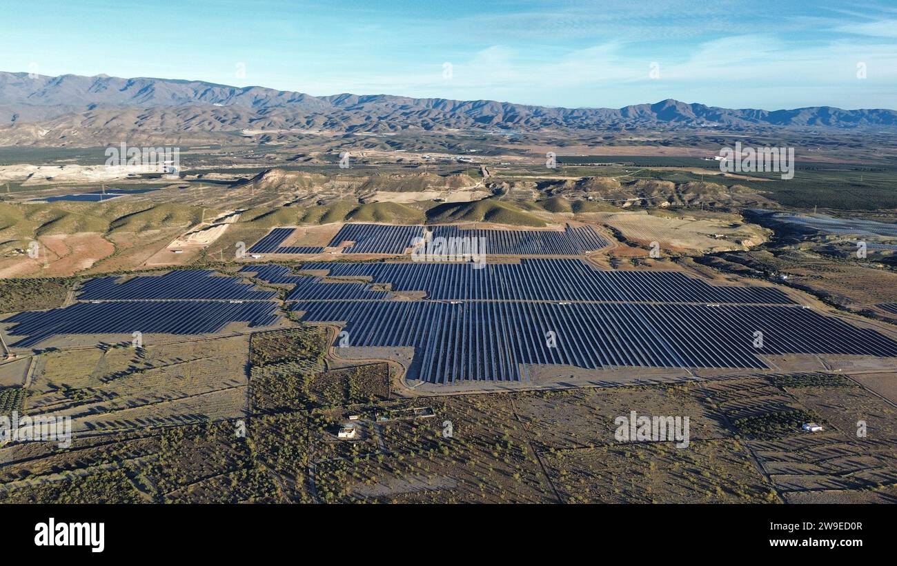 A vast solar farm with multiple photovoltaic panels surrounded by ...
