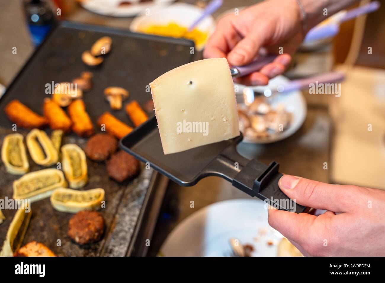 Bavaria, Germany - December 24, 2023: Raclette pans are filled with ...