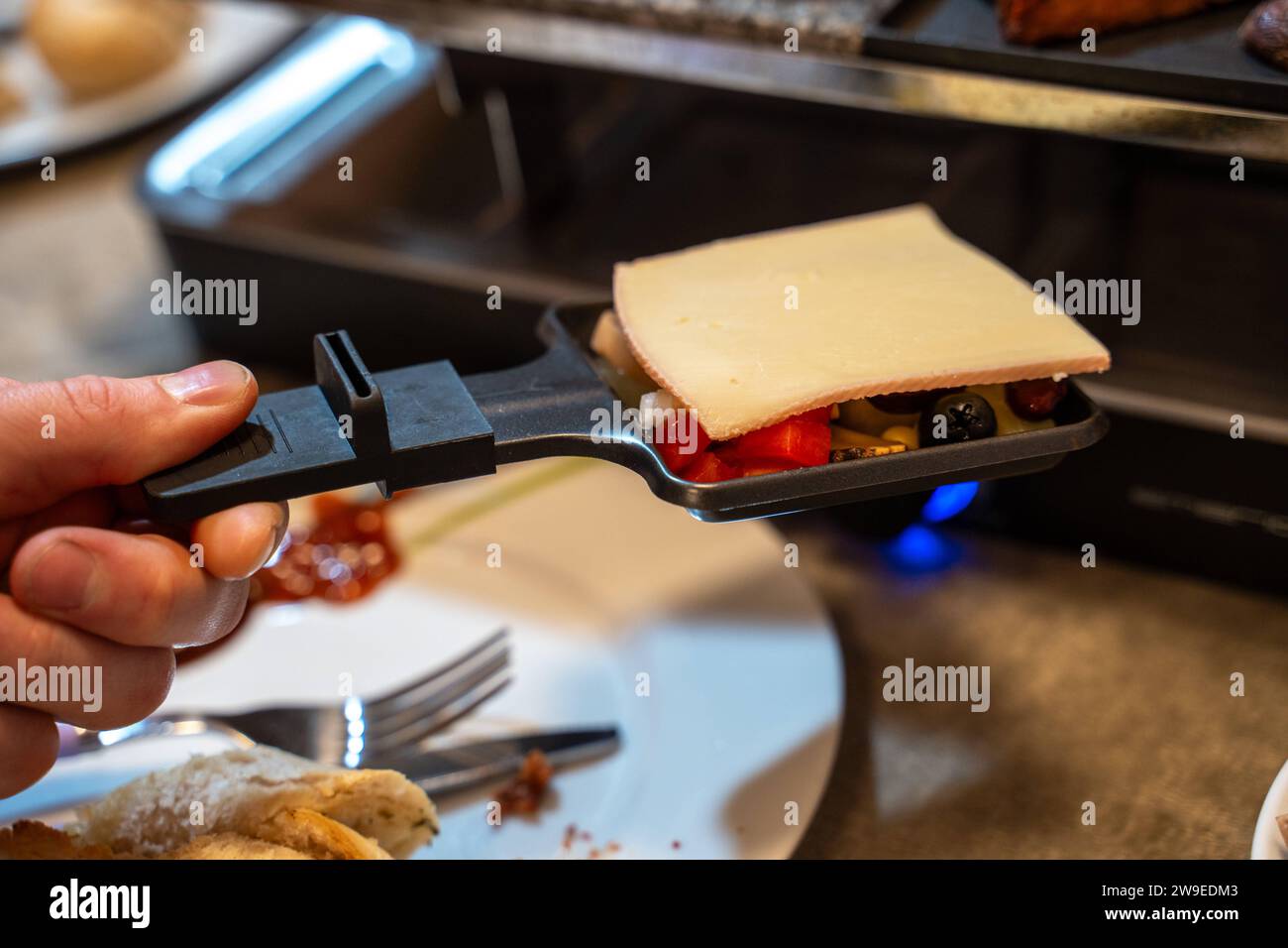Bavaria, Germany - December 24, 2023: Man holding a raclette pan on a ...