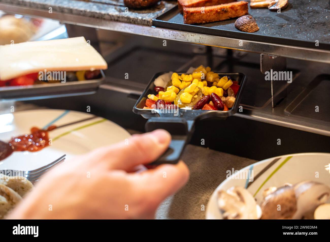 Bavaria, Germany - December 24, 2023: Man holding a raclette pan on a ...