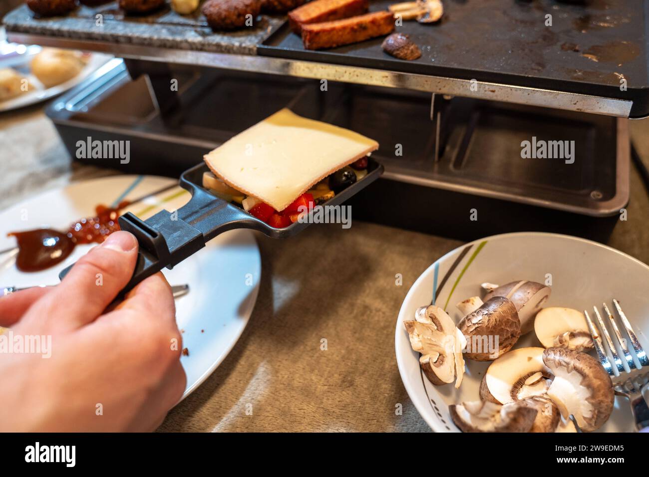 Bavaria, Germany - December 24, 2023: Man holding a raclette pan on a ...
