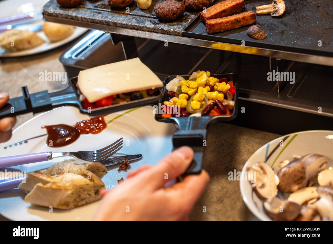 Bavaria, Germany - December 24, 2023: Man holding a raclette pan on a ...