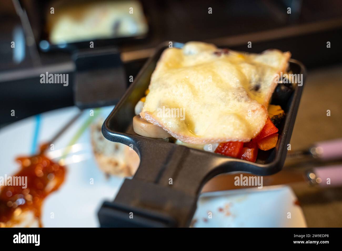 Bavaria, Germany - December 24, 2023: Man holding a raclette pan on a ...