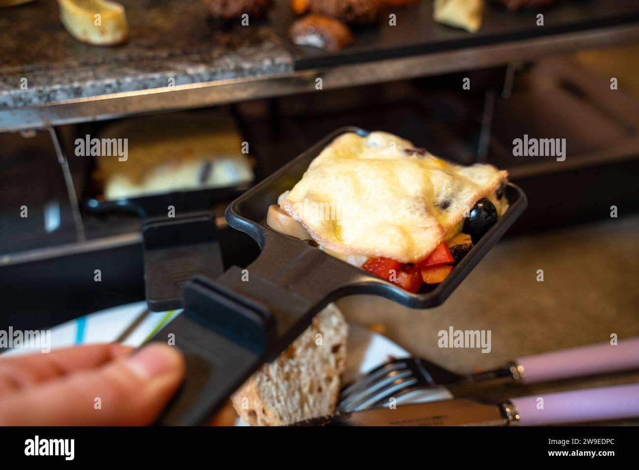 Bavaria, Germany - December 24, 2023: Man holding a raclette pan on a ...