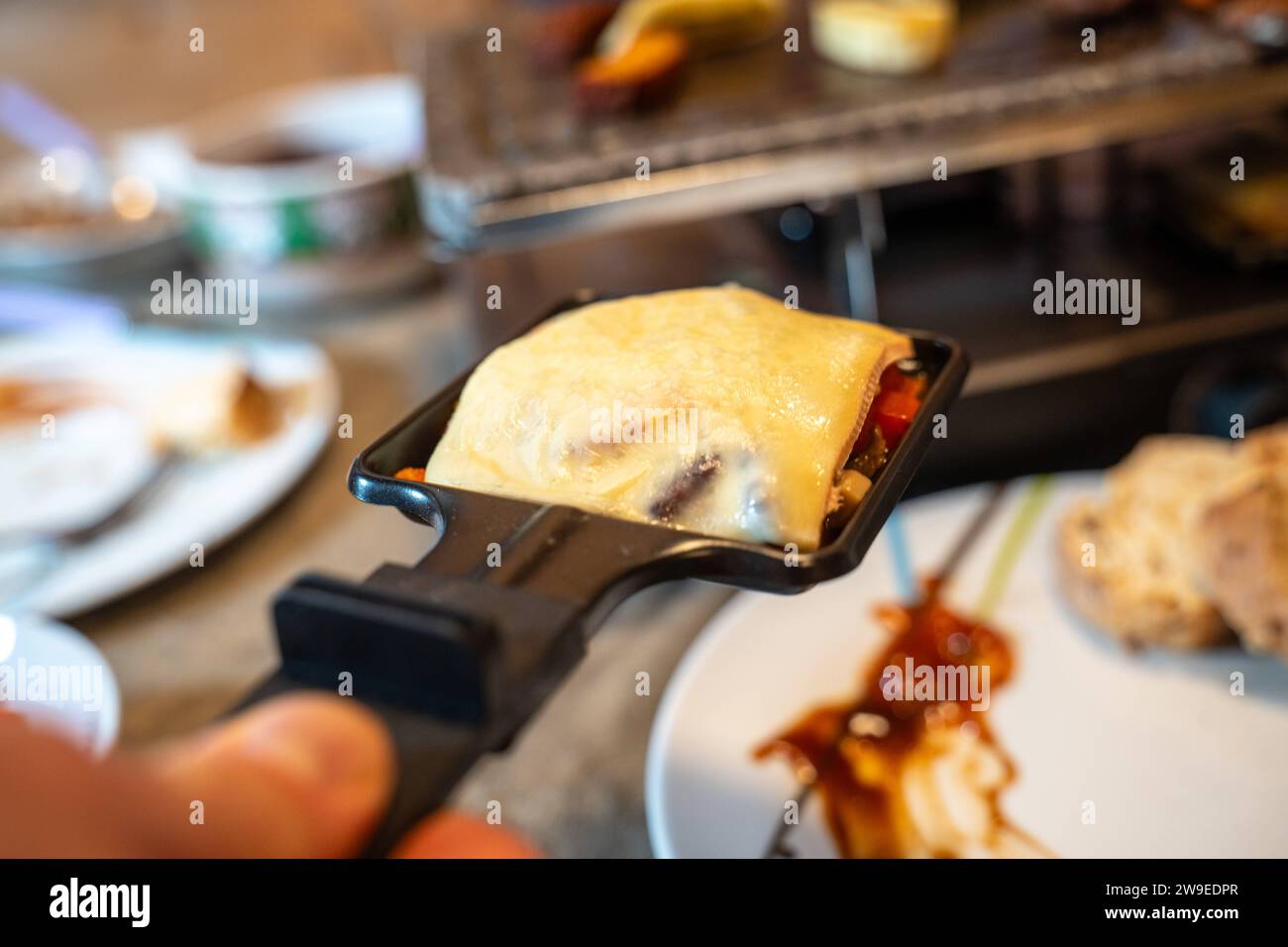 Bavaria, Germany - December 24, 2023: Man holding a raclette pan on a ...