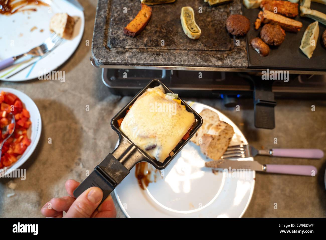 Bavaria, Germany - December 24, 2023: Man holding a raclette pan on a ...
