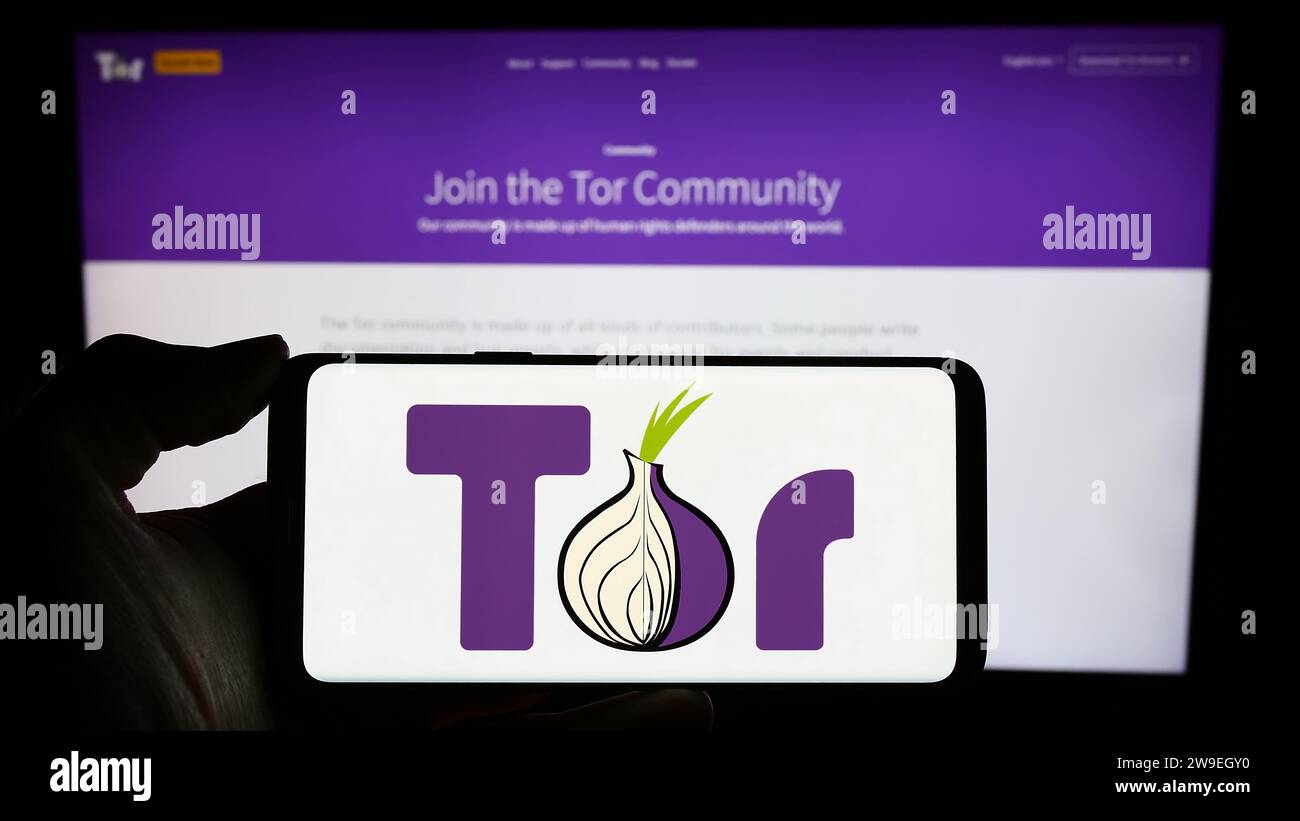 Person holding cellphone with logo of anonymous communication software ...