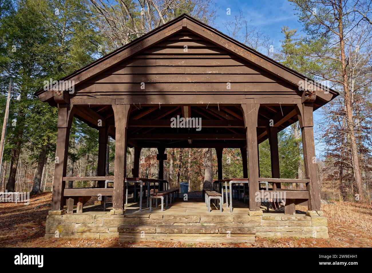 Old rustic picnic shelter with large wooden tables with metal frames ...