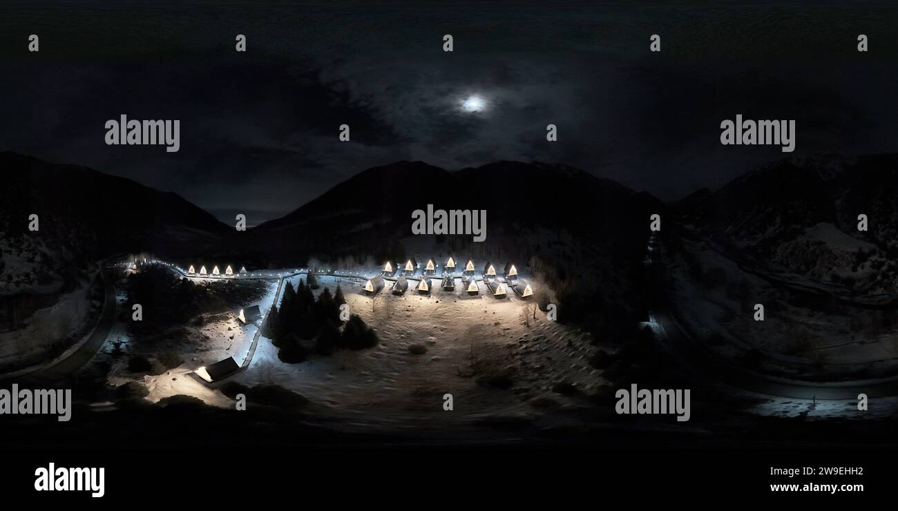 Aerial 360 degree view of A Frame cabins on hill at night in the winter ...