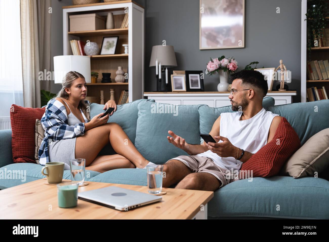 Young married couple husband and wife sitting at home having problems ...