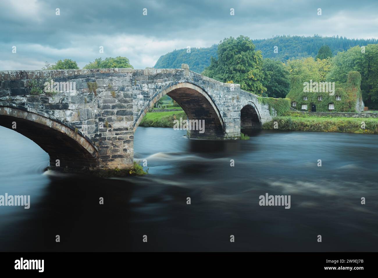 Old Roman inspired bridge Pont Fawr across the River Conwy towards a ...