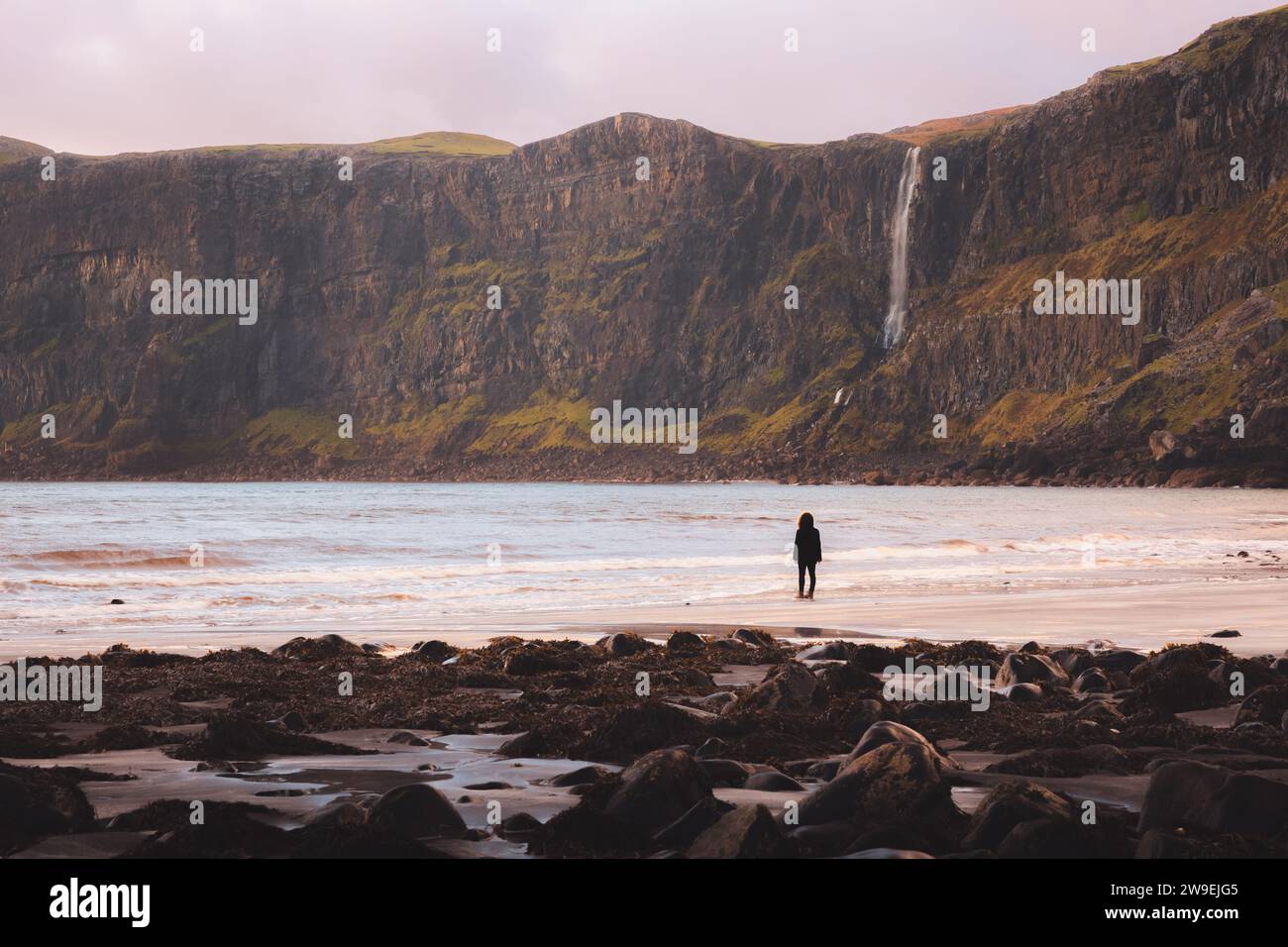 A female tourist alone in nature visits the coastal landscape at ...