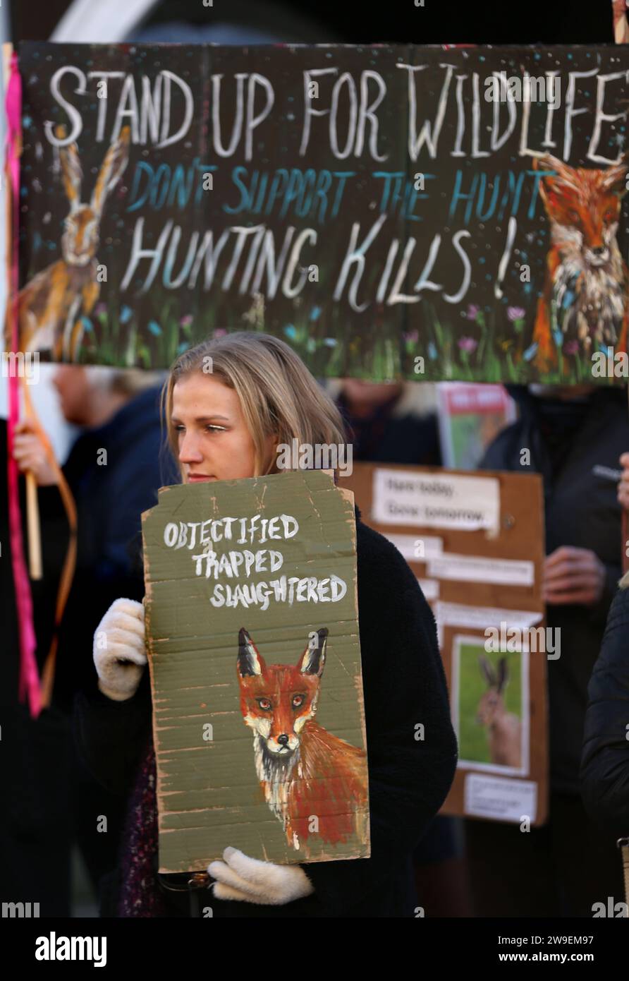 Protesters stand with a banner urging people to not support the hunt ...