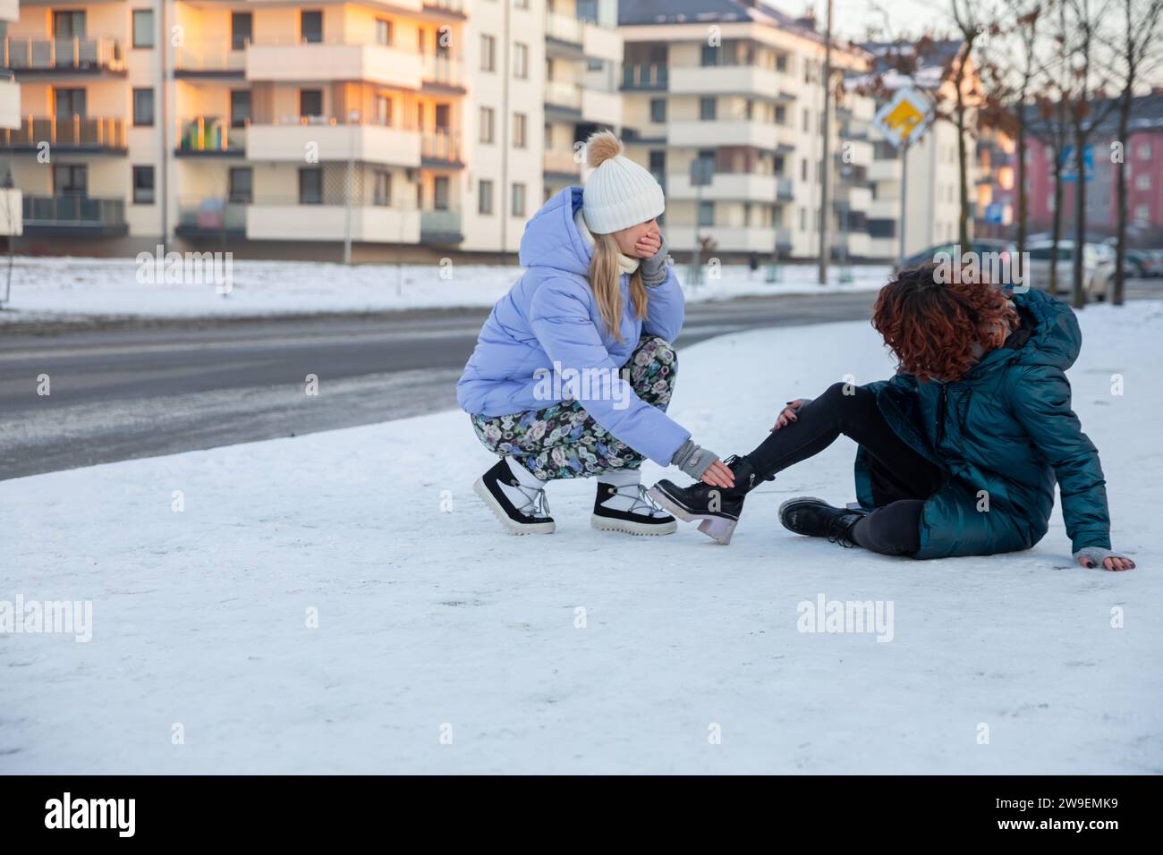 A young girl helps a person who has fallen over get up Stock Photo - Alamy