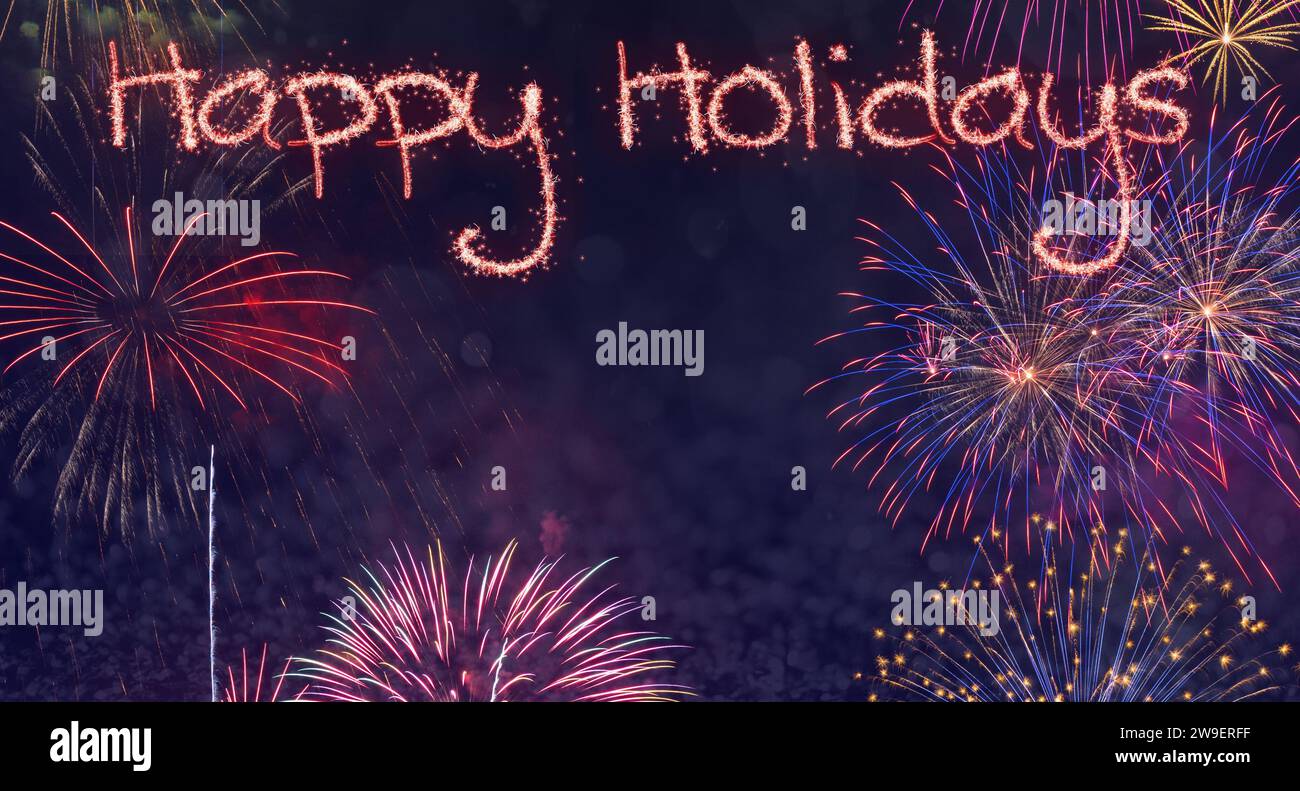 Colorful fireworks in the night sky with a glowing happy holidays ...