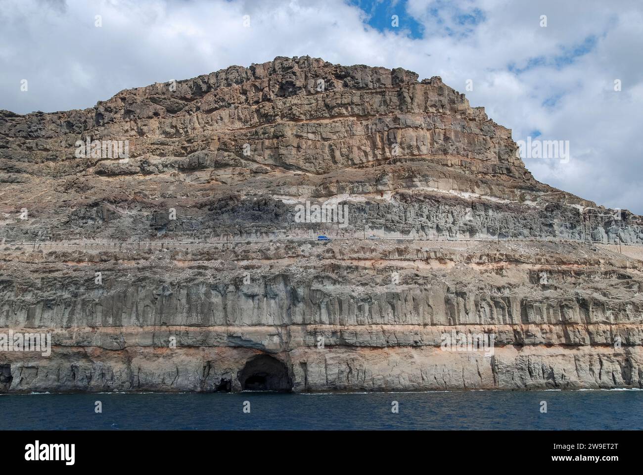 Cliff road with car above sea showing rock strata, Gran Canaria, Canary ...