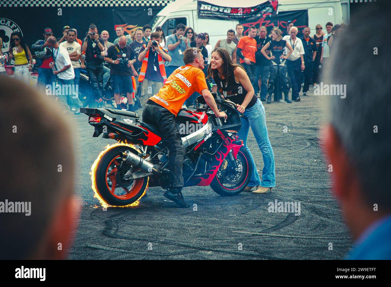 A stunt motorcyclist puts on a show for a crowd of people at a bike meeting in North West London ...