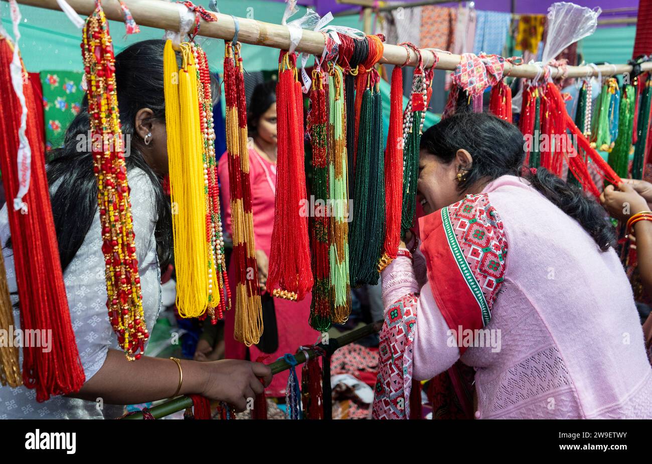 Nepali woman buys traditional beaded necklace at a stall, during North ...
