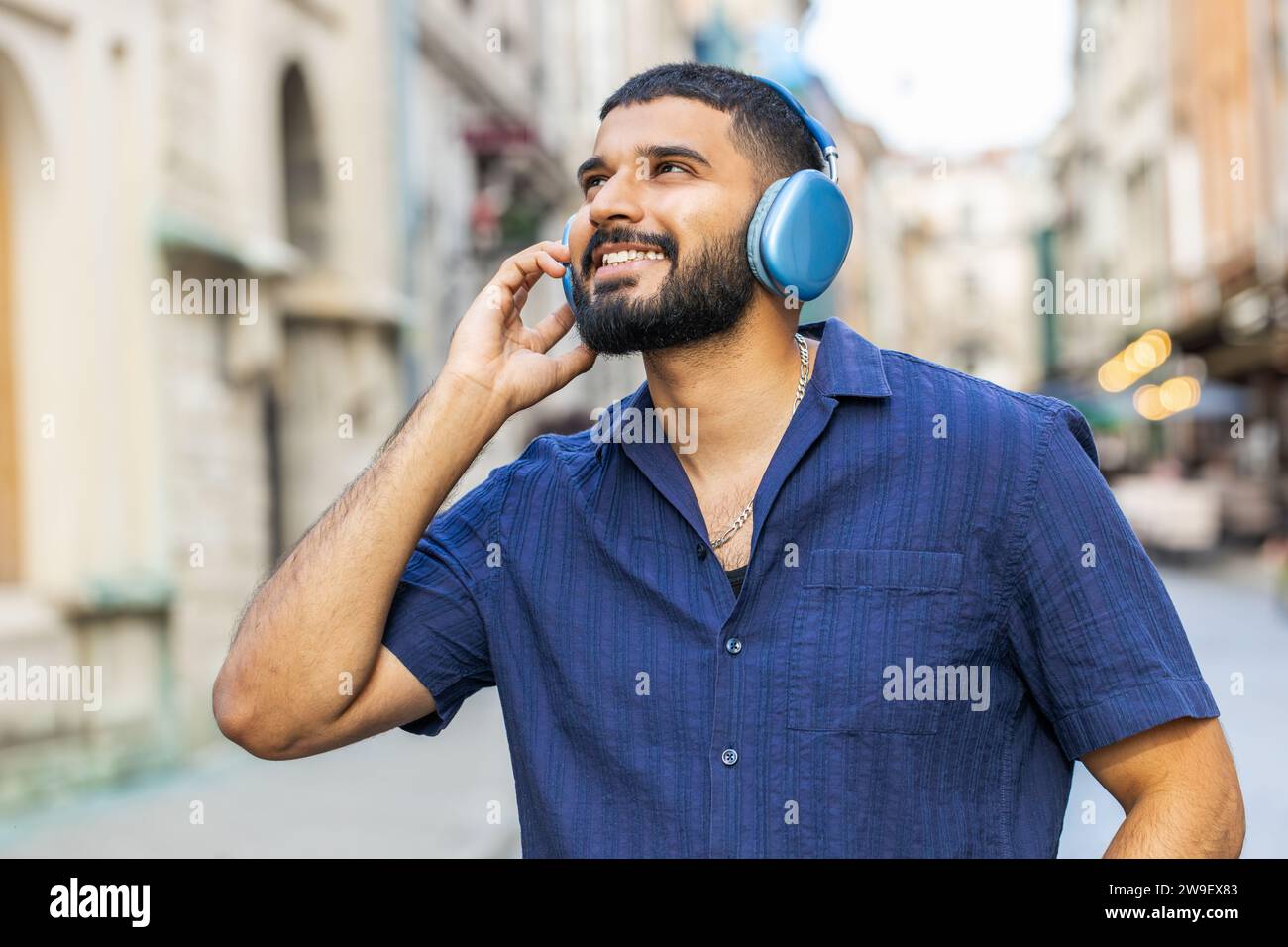 Joyful relaxed overjoyed bearded indian man in wireless headphones ...