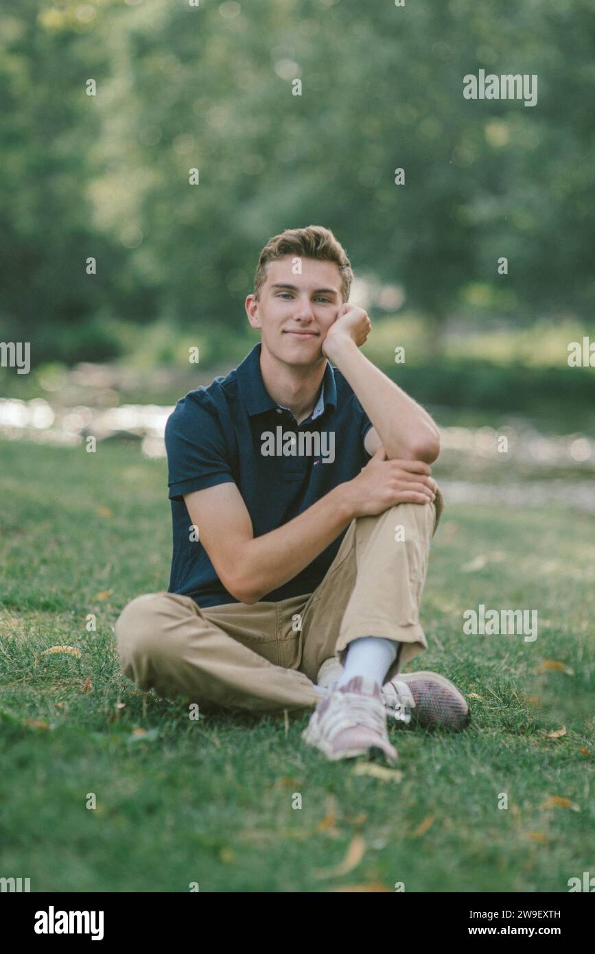 Teenage boy, outdoors, sitting with a creek behind him Stock Photo - Alamy