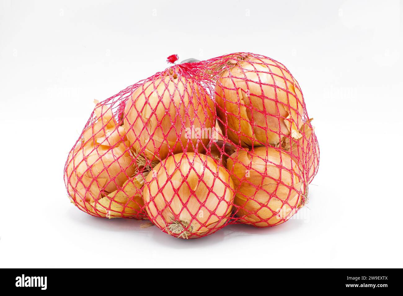 Bag of large yellow cooking onions isolated on white background in red ...