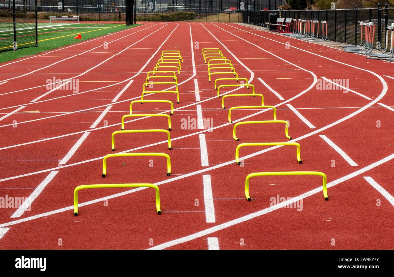 Two rows of small yellow hurdles on a running track in lanes Stock Photo - Alamy