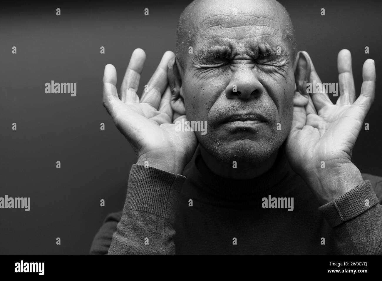 deafness suffering from hearing loss on grey black background with ...