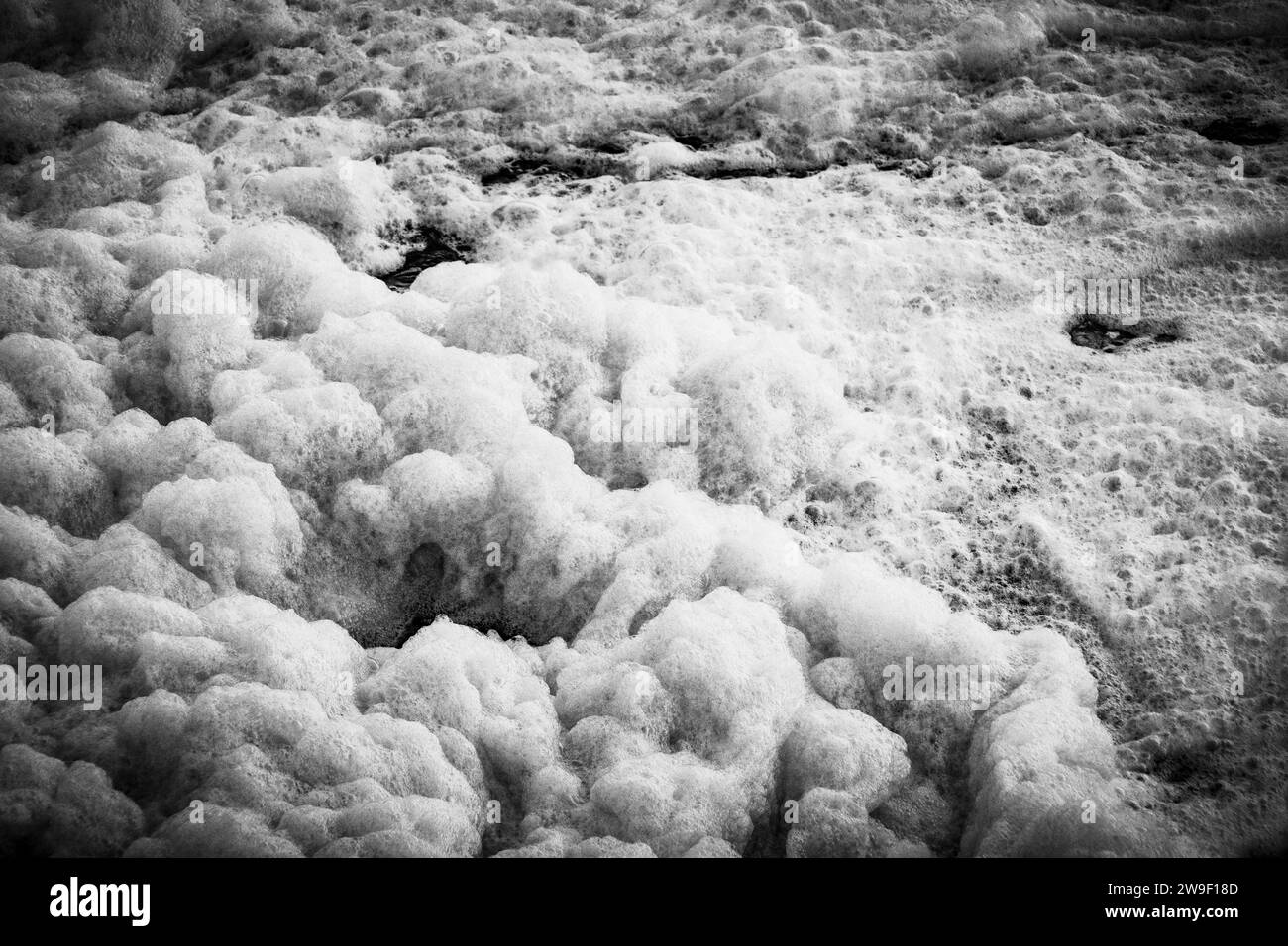 Water flows over a dam structure and crashes to the bottom of the ...