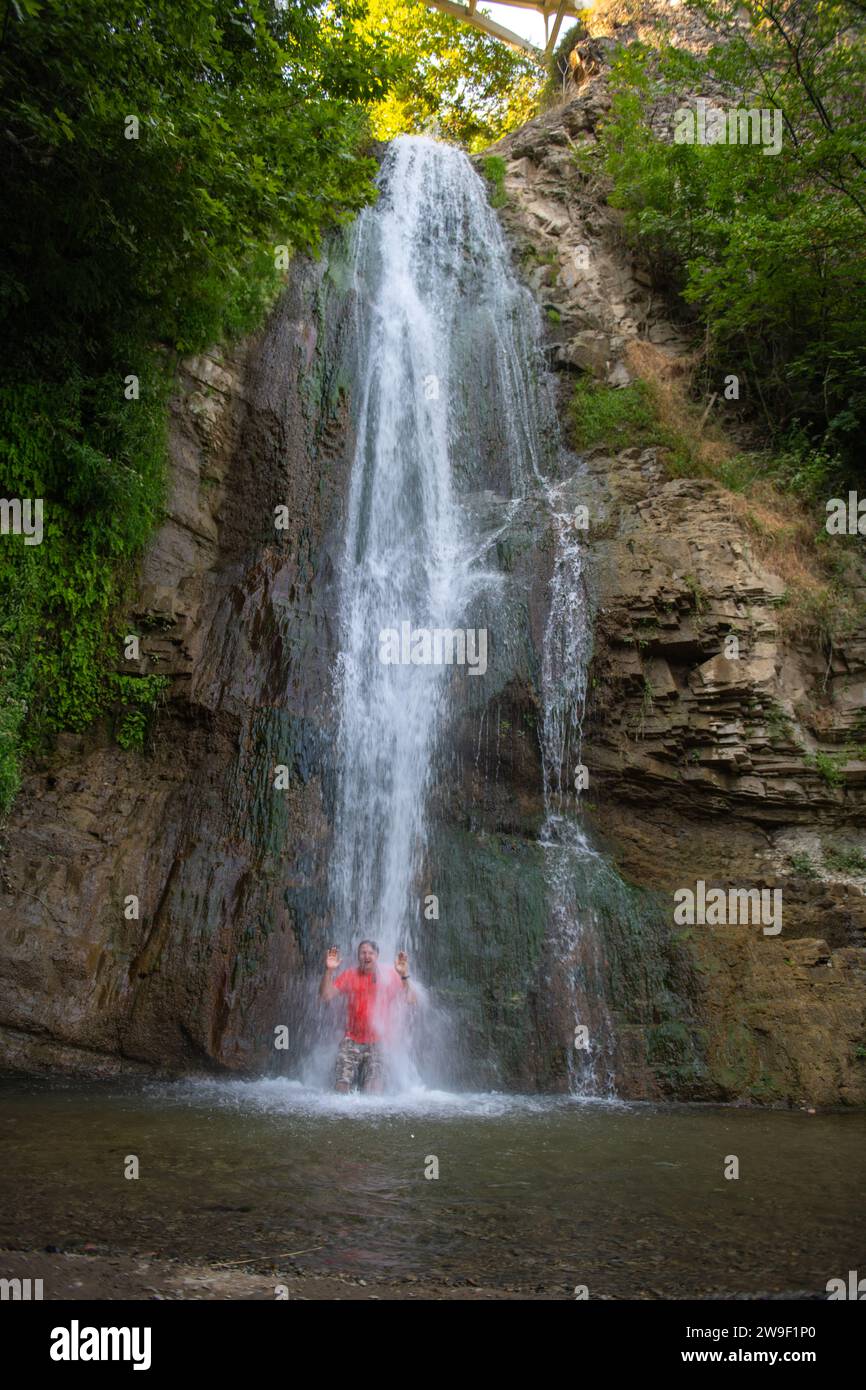 Untamed Spirit: Man Embracing the Cascade in Red Garments Stock Photo ...