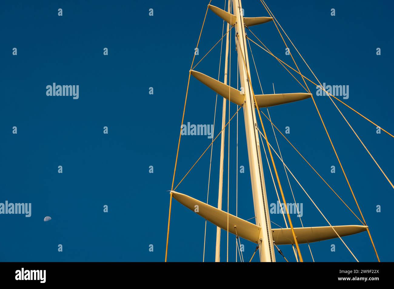 Mast and rigging onboard a large sailing yacht set against blue sky ...
