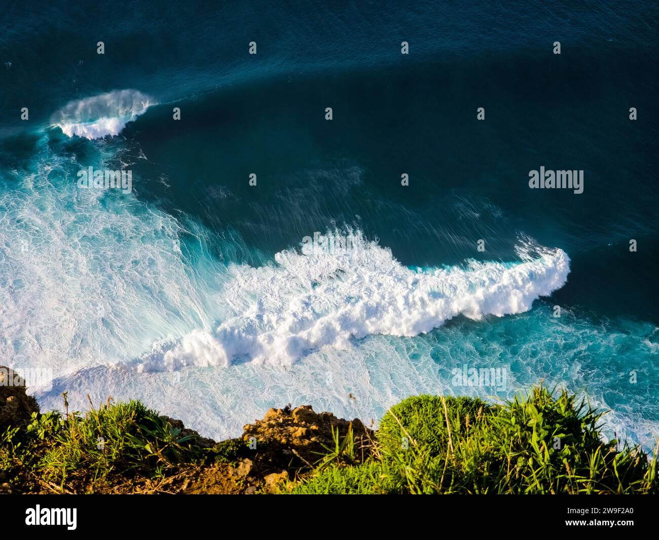 A stunning landscape featuring waves crashing against rocky cliffs ...