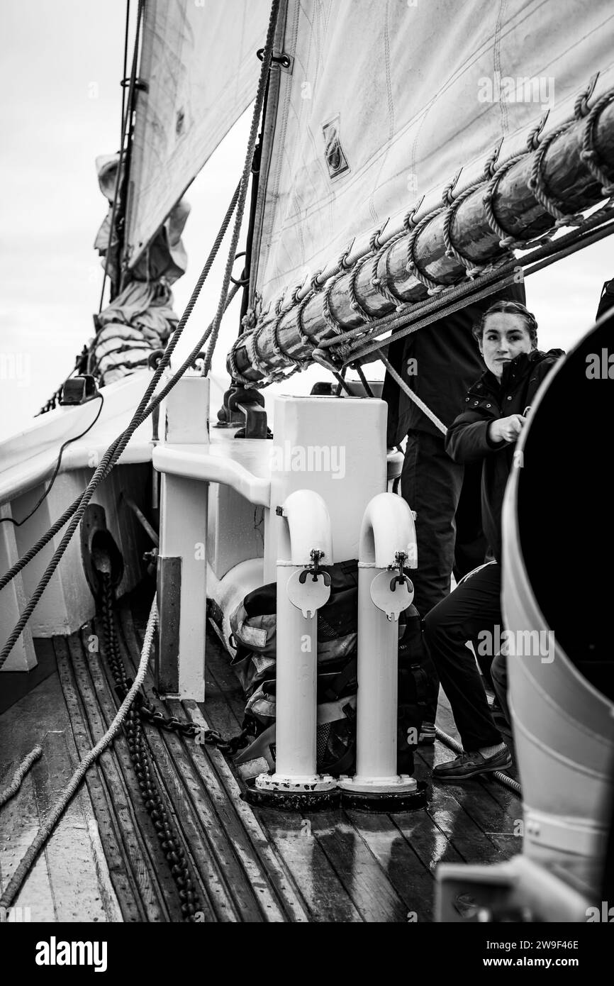 Crew at the bow onboard the replica Grand Banks fishing schooner ...
