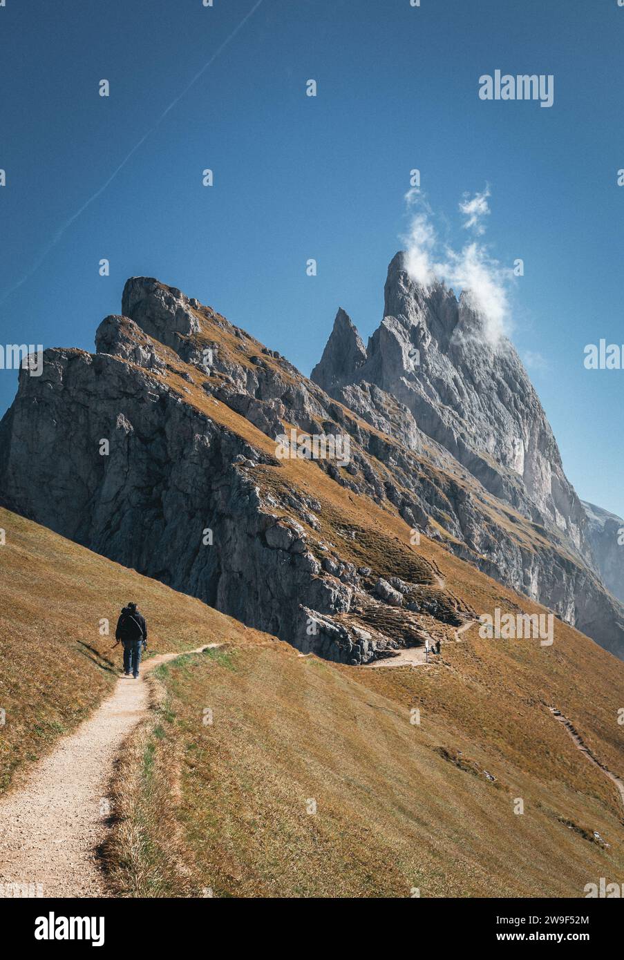 A determined individual is making their way up a rugged mountain path ...