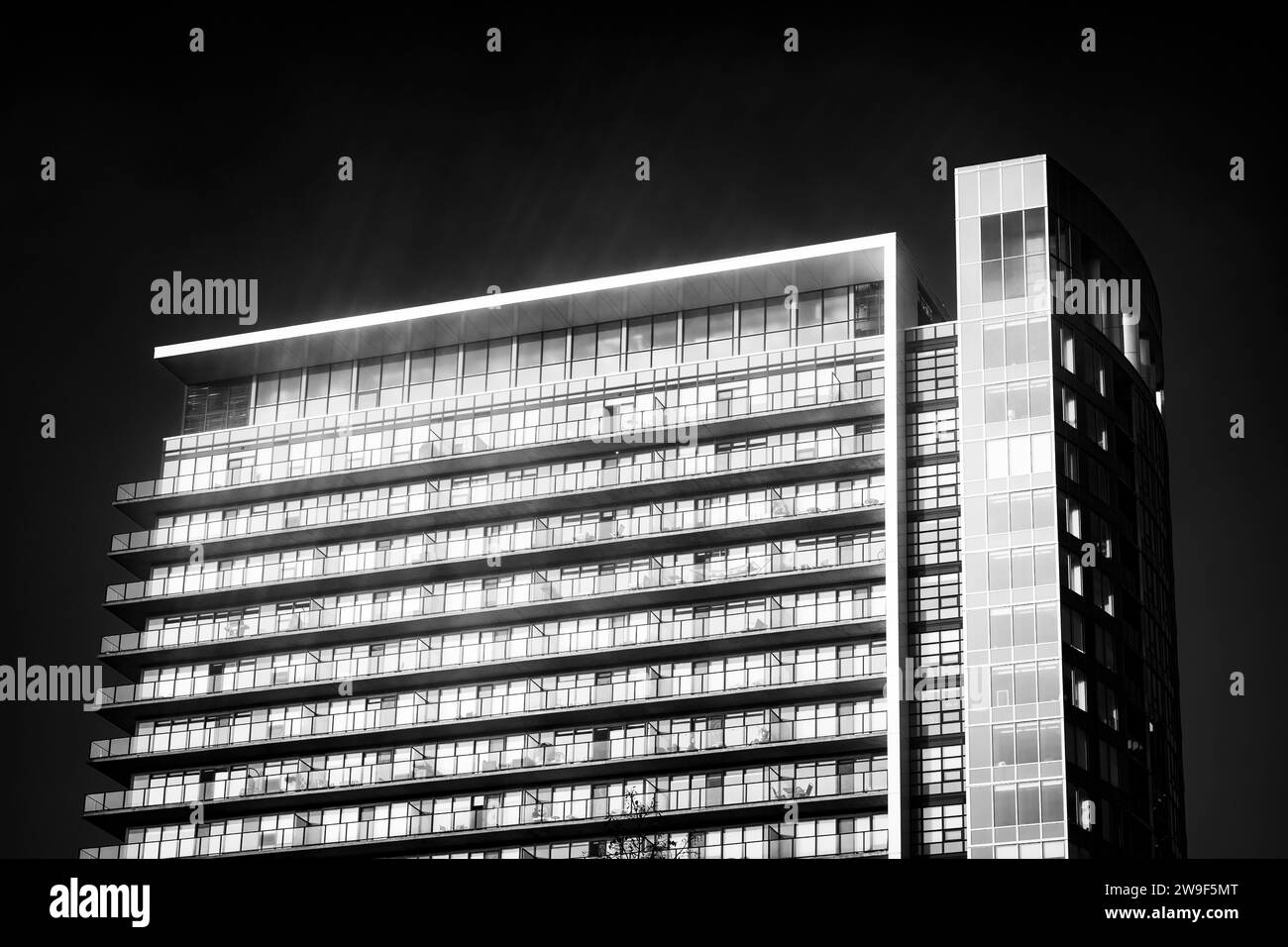 Sun glare off the windows of a tall apartment building Stock Photo - Alamy