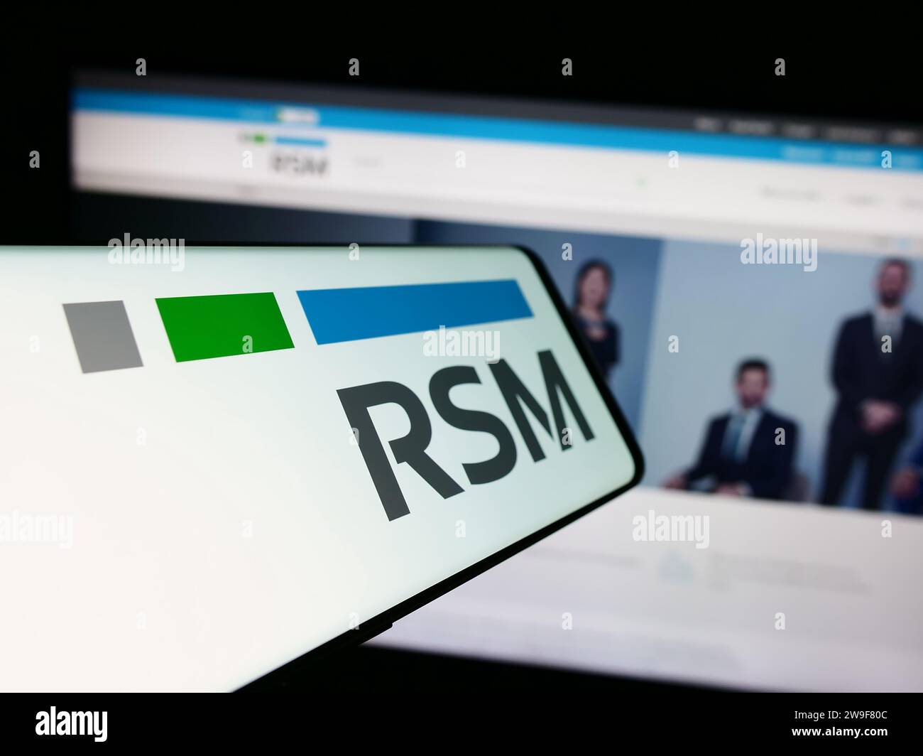Smartphone with logo of global accounting company RSM International Ltd. in front of business ...