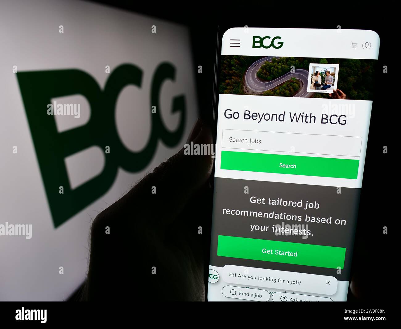 Person holding cellphone with website of US company Boston Consulting ...