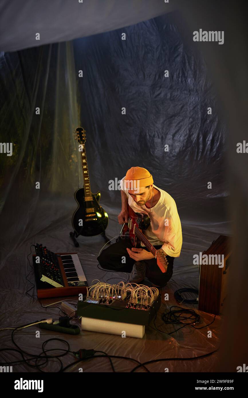 Vertical high angle shot of adult male musician with electric guitar ...