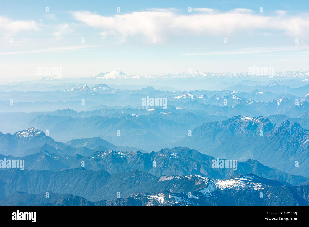 Expansive aerial view of mountain ranges with Mt Baker in the distance ...