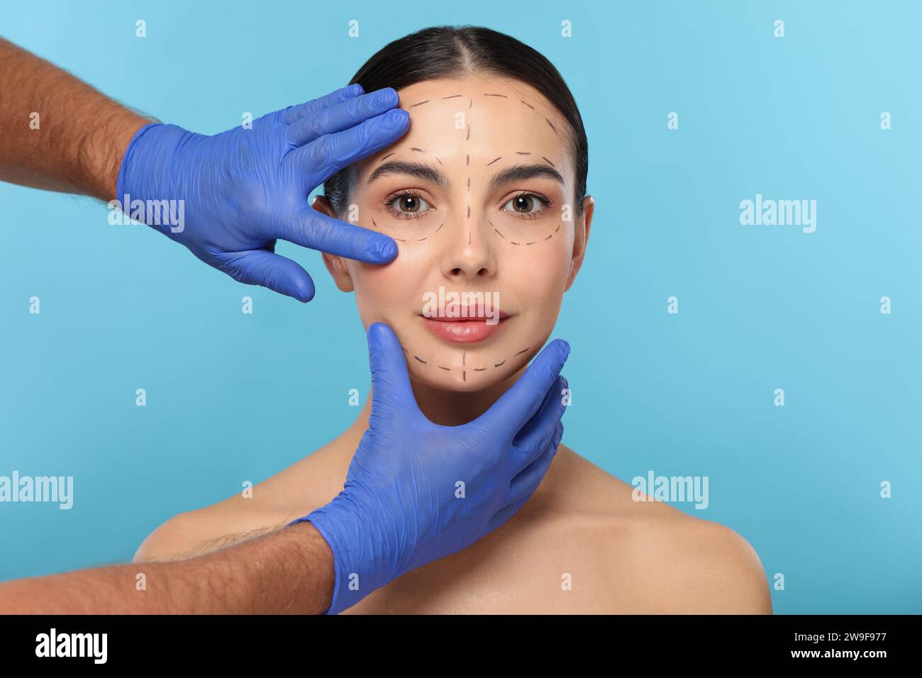 Doctor checking patient's face before cosmetic surgery operation on ...