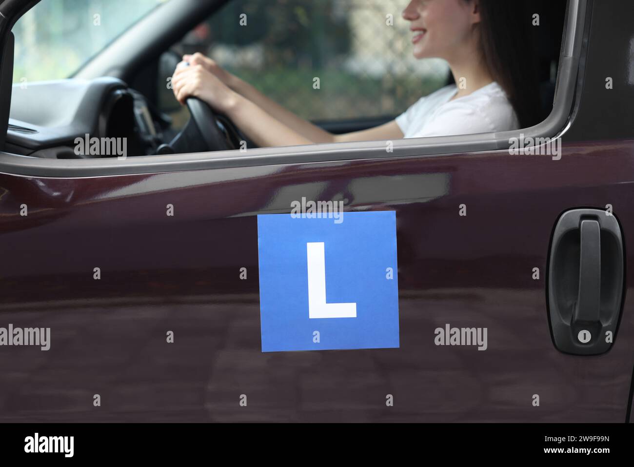 Learner driver driving car with L-plate, view from outside. Driving ...